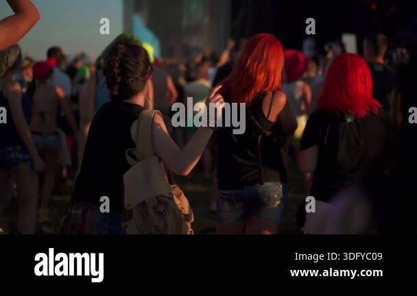 Girls with hands up dancing, singing and listening the music during ...