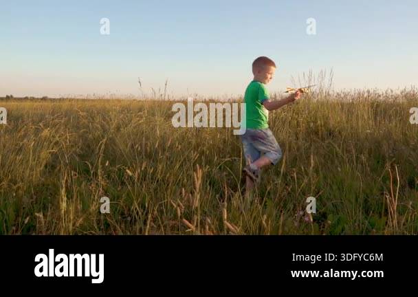boy in wheat field playing with a toy plane Stock Video Footage - Alamy