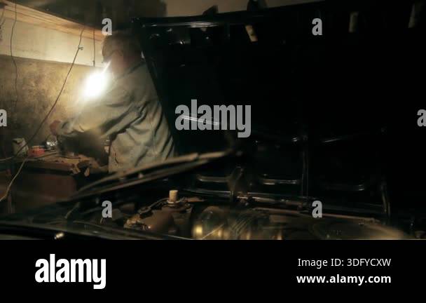 Professional car mechanic working in dark garage Stock Video Footage ...