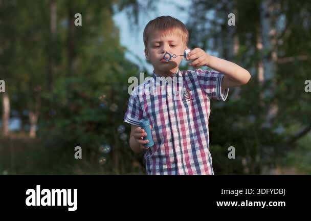 cute boy outdoor playing with soap bubbles Stock Video Footage - Alamy