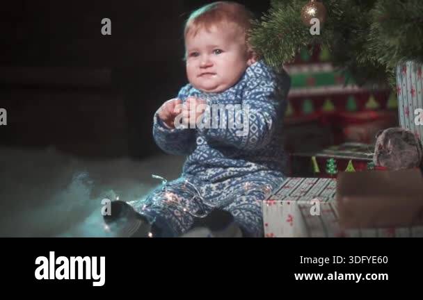 Baby boy near Christmas tree with gifts Stock Video Footage - Alamy