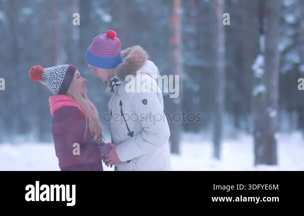 Happy couple in love under snowfall Stock Video Footage - Alamy