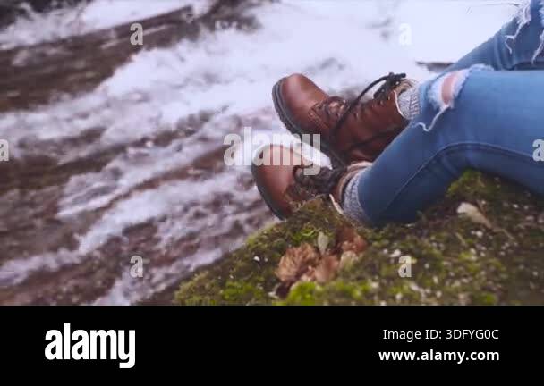 Girl hanging her feet over a stream in a forest Stock Video Footage - Alamy