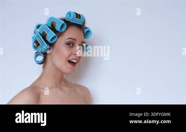 Beautiful happy girl in hair curlers isolated Stock Video Footage - Alamy