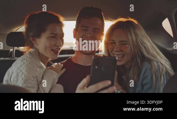 Group of friends taking a selfie into the car before leaving for ...