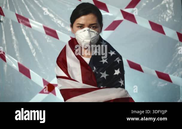 Tragedy of USA. Woman in protective mask wrapped in american flag on ...