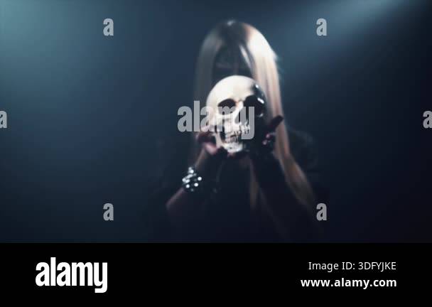Gothic woman with horror paint on face standing in darkness lend a ...