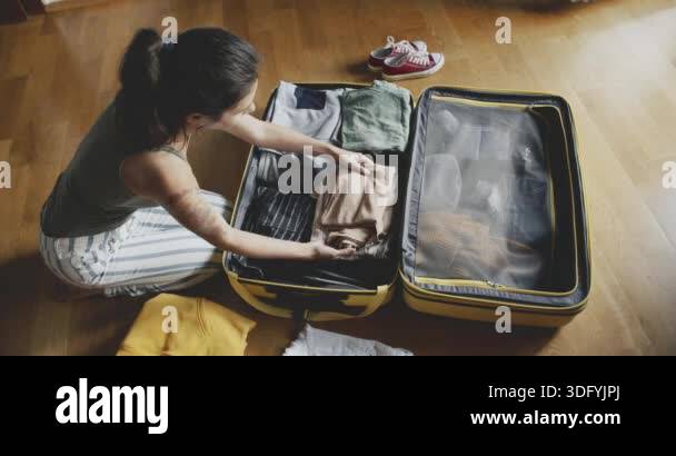 The girl closes the suitcase. The concept of moving, vacation, vacation ...