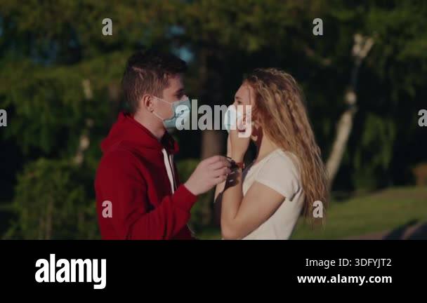 Young man and woman take off medical mask and kiss. Pandemic is over ...