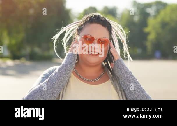 Close-up portrait of joyful young woman with bright hair, pink colorful ...