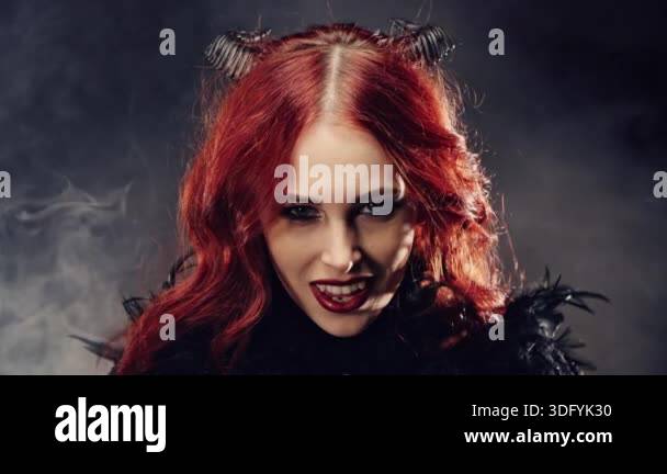 Portrait witch girl with red hair and devil horns. Woman smiling ...