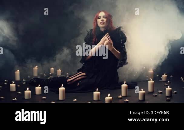 Red-haired witch sitting on floor in smoke, making energetic hand ...
