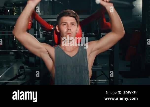 Athletic young man portrait in gym. Muscular sportsman engaging in ...