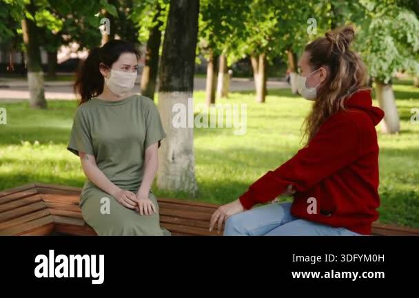 Young pretty girls talk to each other in protective masks from the ...
