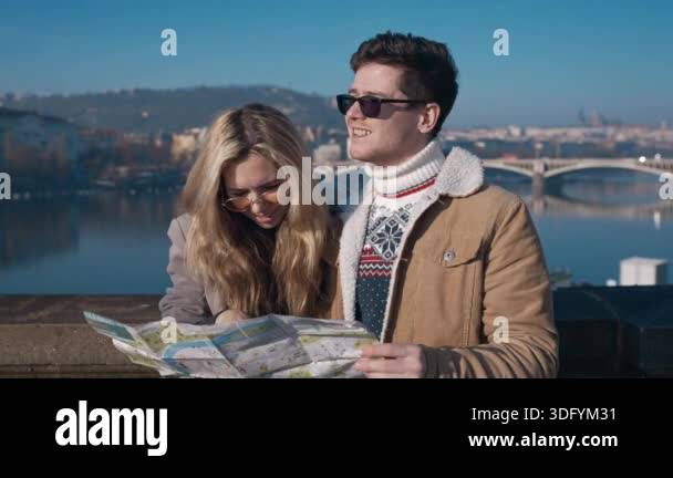 Young couple tourists examining the map of Prague. Tourism, travel ...