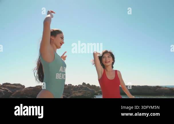 Two beautiful young girls posing on magnifficent sea beach. Women ...
