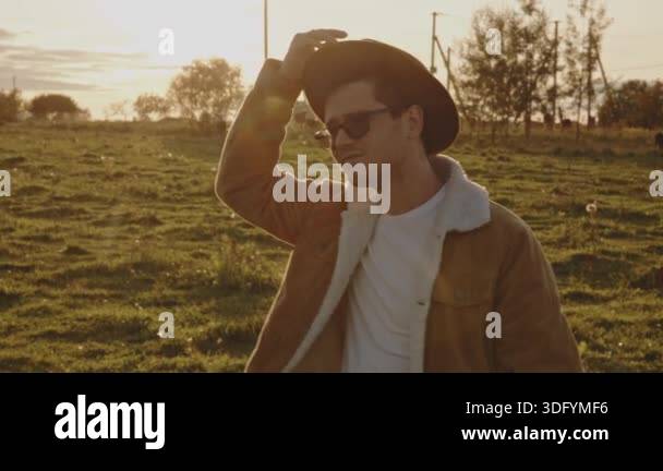 Portrait of young caucasian guy on farm in front of fields or meadows ...