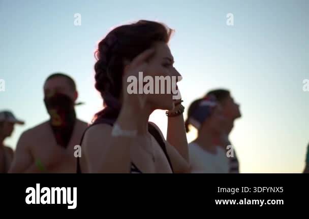 naughty asian woman dancing at sunset light among the crowd of people ...