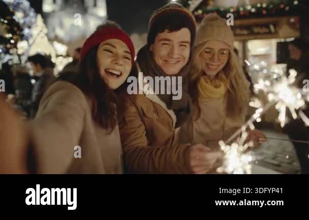 Happy women and man having fun with bengal lights outdoors at the Xmas ...