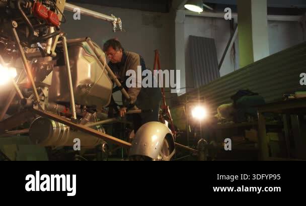 Plane engineer working. Male pilot and agiculture biplane in garage ...