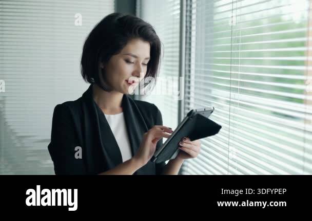 Portrait of young business woman in office talking on phone and smiling ...