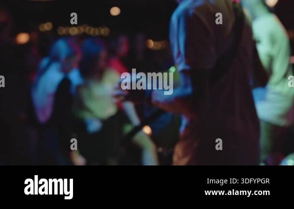 Band on stage dancing along with the crowd during performance ...