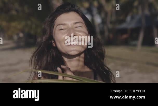 Portrait of mixed race asian woman smiling under coco palm tree. Happy ...