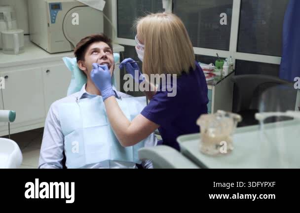 Dentist carrying out a thorough examination. Portrait of young man at a ...