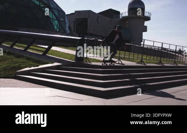 Skateboarder flying over the steps. Handsome athletic man spending time ...