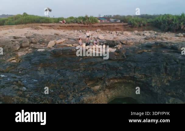 Magnifficent Aerial scene of tourists relaxing on top of cliff ...