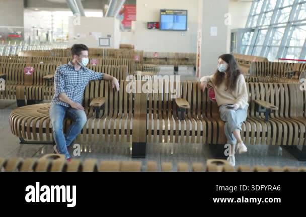 Two travelers woman and man communicating in medical mask keeping safe ...