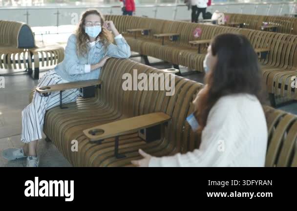 Two travelers women communicating in mask keeping safe distance in ...