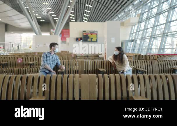 Two travelers woman and man communicating in medical mask keeping safe ...