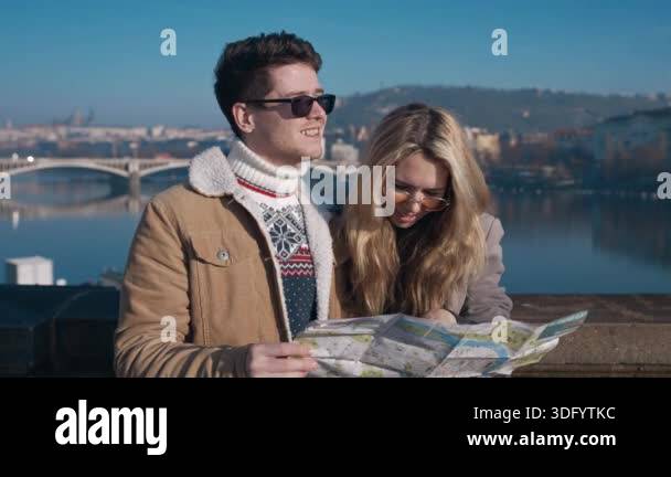 Young couple tourists examining the map of Prague. Tourism, travel ...