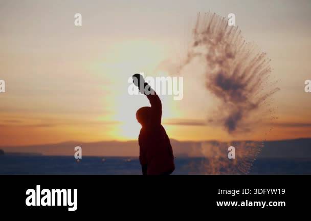 Portrait of person standing on surface of frozen lake at dusk, spilling ...