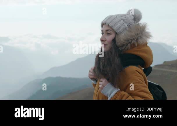 Portrait of multiracial woman tourist looking at cloudy mountains at ...