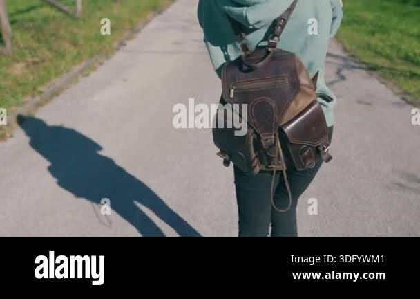 Young girl in red cap carrying a small dog on her shoulder and walking ...
