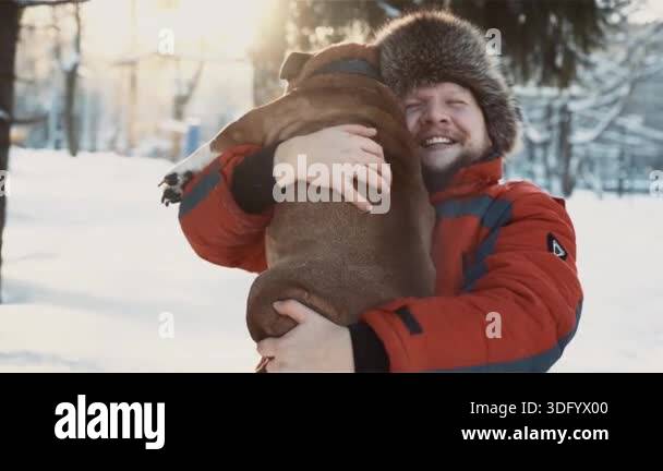 Happy bearded man hugging his bulldog at winter sunny day. Friendship ...