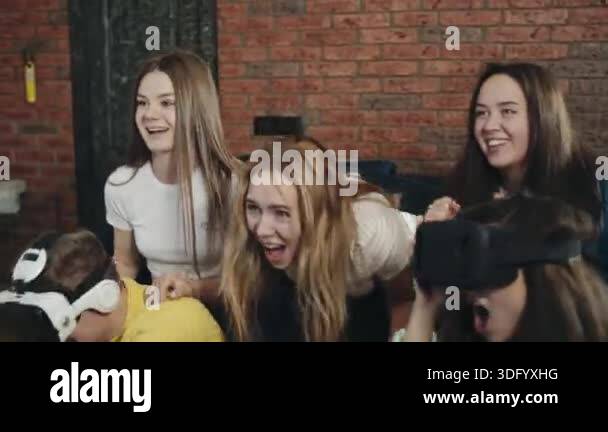 Charismatic group of teenagers watching friends playing competative ...