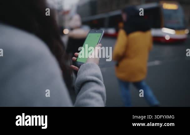 Girl using green screen mobile app on touchscreen of smartphone to call ...