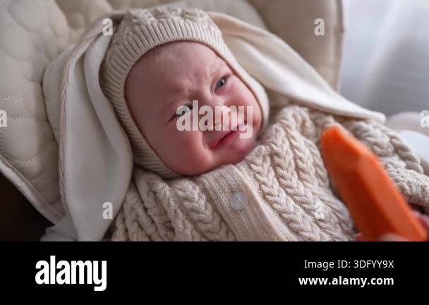 Cute baby eats vegetables, his mothers hand gives him carrots. Diet and ...