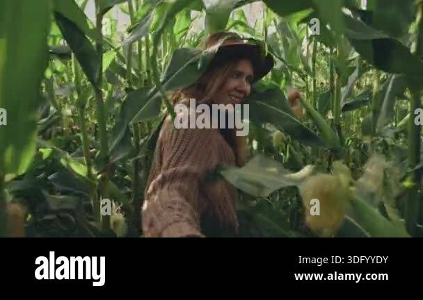 Follow me shot of young woman in brown hat pulling her boyfriend across ...