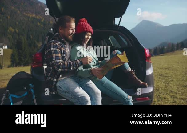 Social distancing together. Pretty lovers studying the map and sitting ...