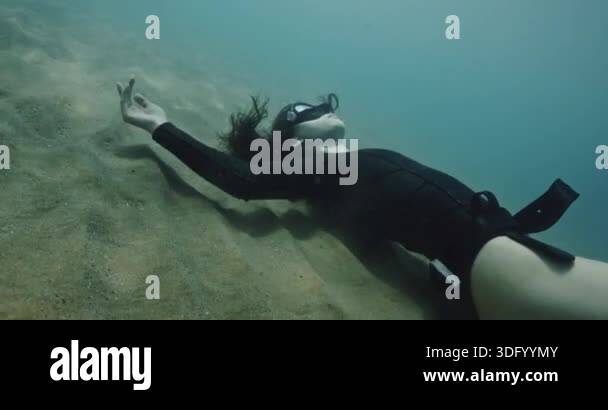 Diver woman lying underwater bottom, filmed on cinema camera. Brutal ...
