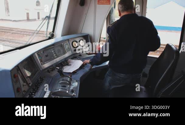 steam train driver looking out of his cab at a station stop. Train ...