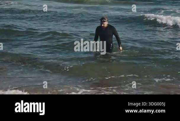 Adult man in diver suit swimming in the sea. Cute young man swimmer ...