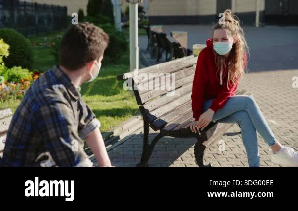 Social distancing. Young people sitting on different benches at safe ...