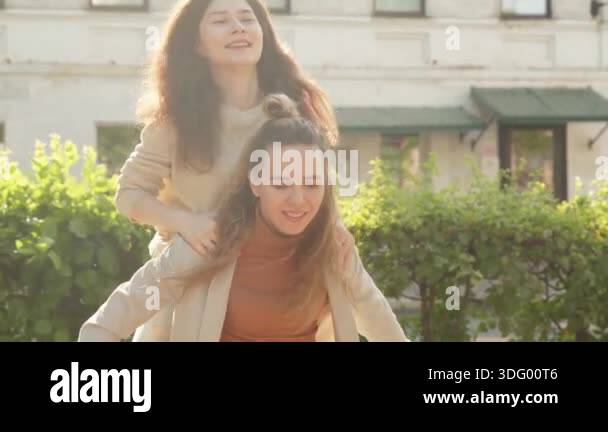 Two girls laugh and smile at sunset sunlight. Happy friends have fun ...