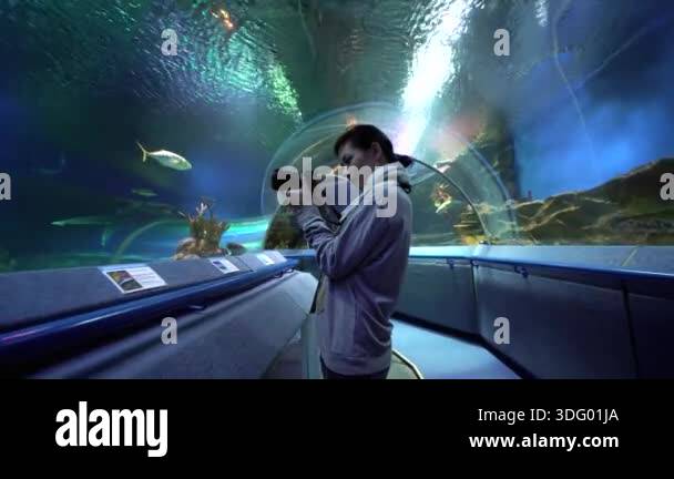 Side portrait of girl with audioguide standing on moving walkway ...