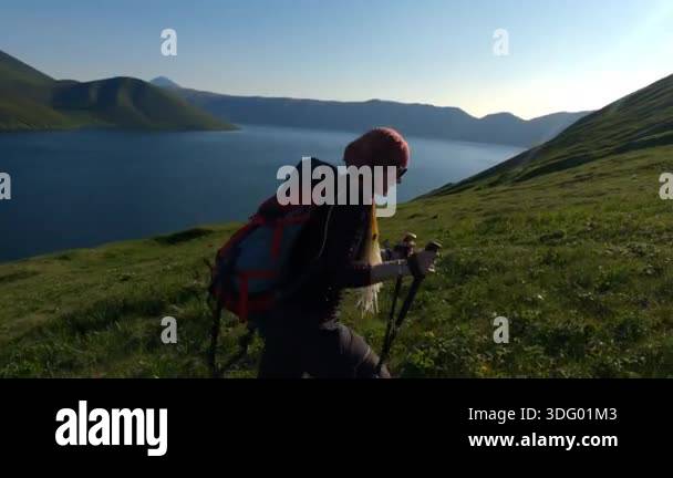 Tourist walking on krenitsyn volcano on the Kuril islands, watching the ...